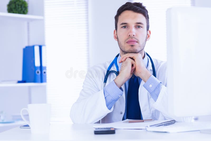 Portrait of Doctor Looking at Camera with Hands Folded Stock Image ...