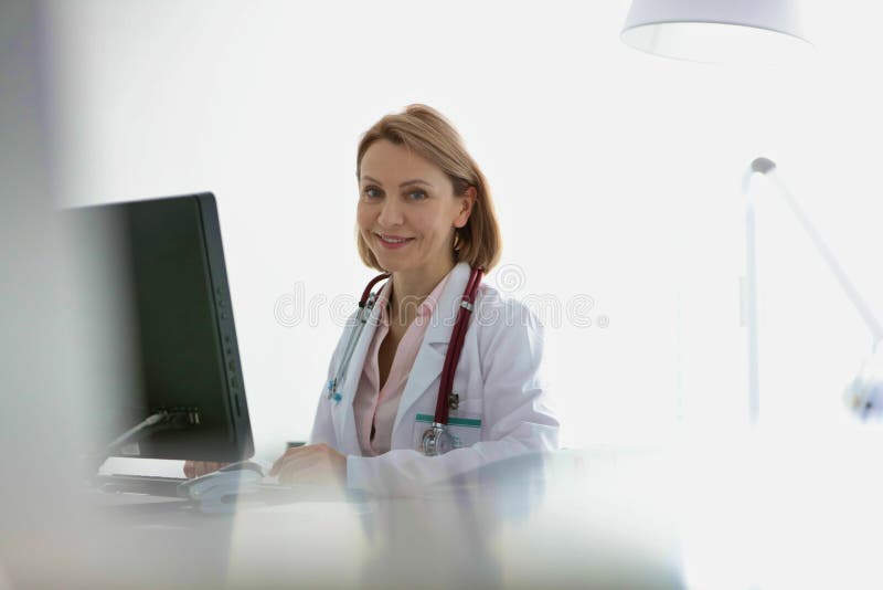 Doctor Sitting at Computer Desk in Hospital Stock Photo - Image of ...