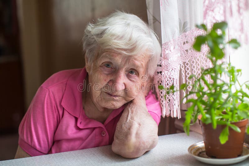 Portrait of Elderly Sad Woman Sitting at the Table in the House. Stock ...