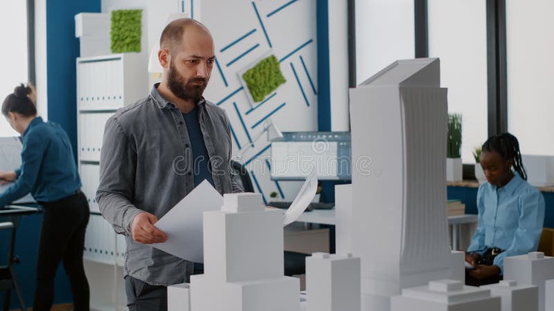 Portrait of Engineer Analyzing Blueprints Plan and Building Model To ...