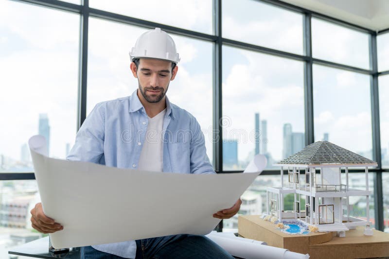 Portrait of Engineer Looking at Camera while Reading Project Plan ...
