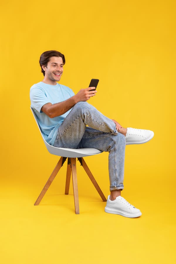 Happy Guy Using Cell Phone at Studio, Sitting on Chair Stock Image ...