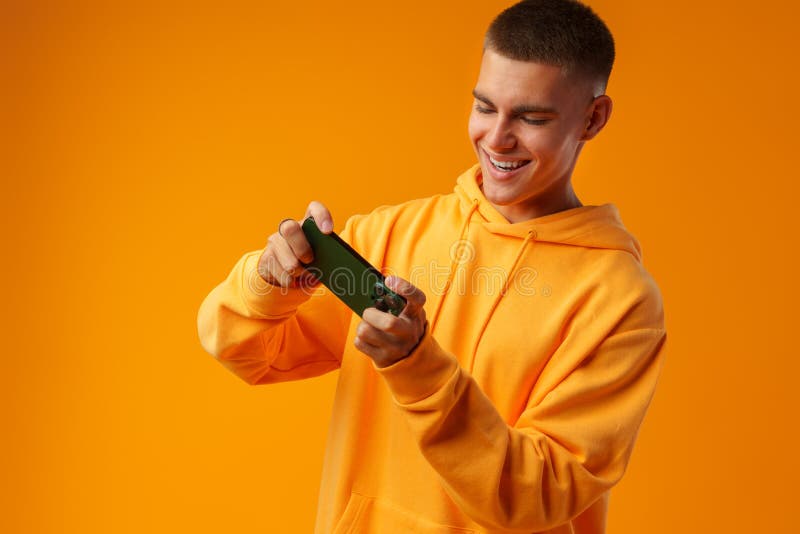 Portrait of Excited Young Man Playing Online Game on Mobile Phone on ... Portrait of Excited Young Man Playing Online Game on Mobile Phone on ...