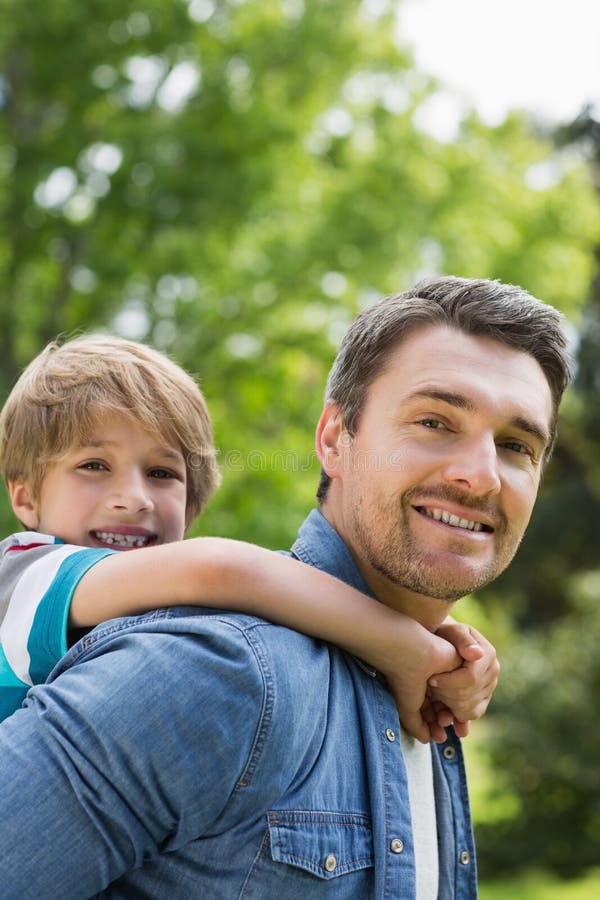 Portrait of a Father Carrying Young Boy on Back Stock Image - Image of ...