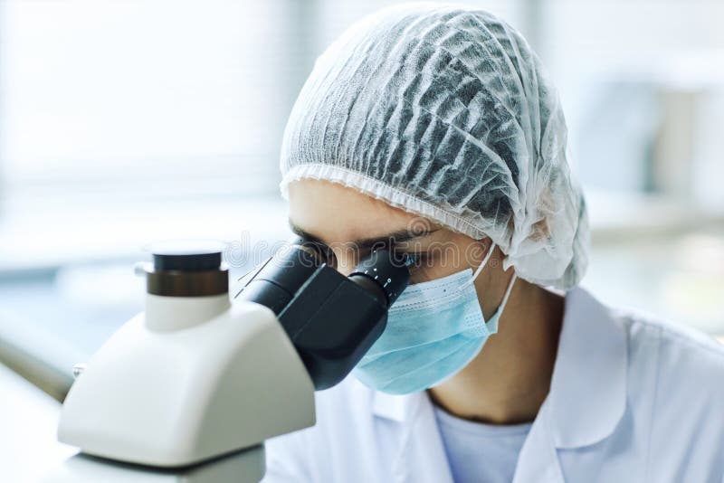 Female Bio Engineer Looking in Microscope Working in Scientific ...