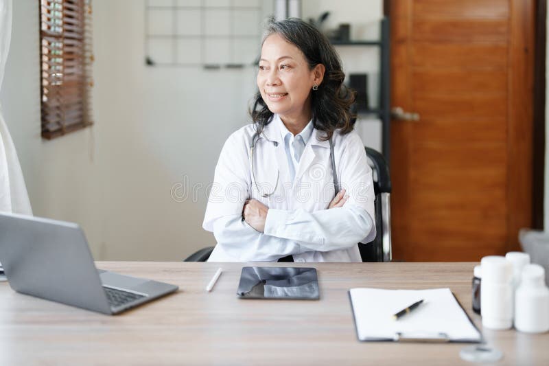 Portrait of a Female Doctor Using a Computer and a Document Analyzing a ...