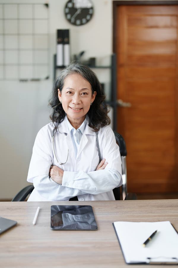 Portrait of a Female Doctor Using a Computer and a Document Analyzing a ...