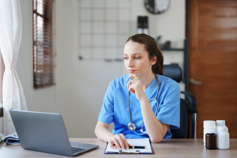 Portrait of a Female Doctor Using a Computer and a Document Analyzing a ...