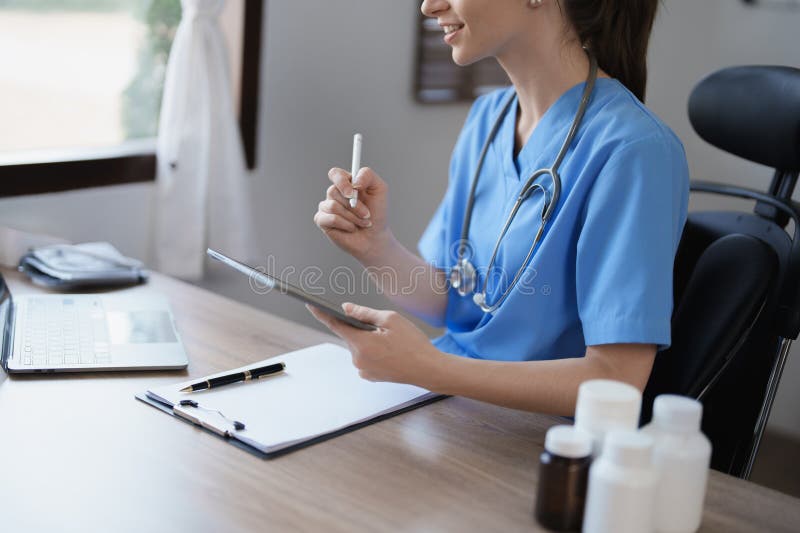 Portrait of a Female Doctor Using a Computer and a Document Analyzing a ...