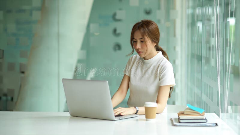 Portrait of Female Doing Assignment with Laptop and Stationery in Co ...