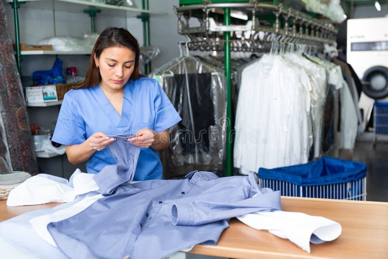 Portrait of Female Laundry Worker Examining Clean Garments Stock Photo ...