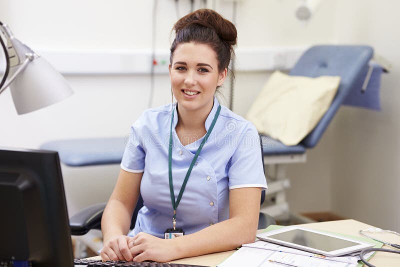 Portrait of Female Nurse Working at Desk in Office Stock Image - Image ...