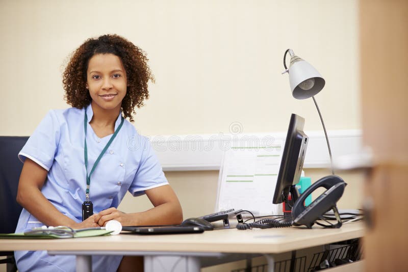 Portrait of Female Nurse Working at Desk in Office Stock Photo - Image ...