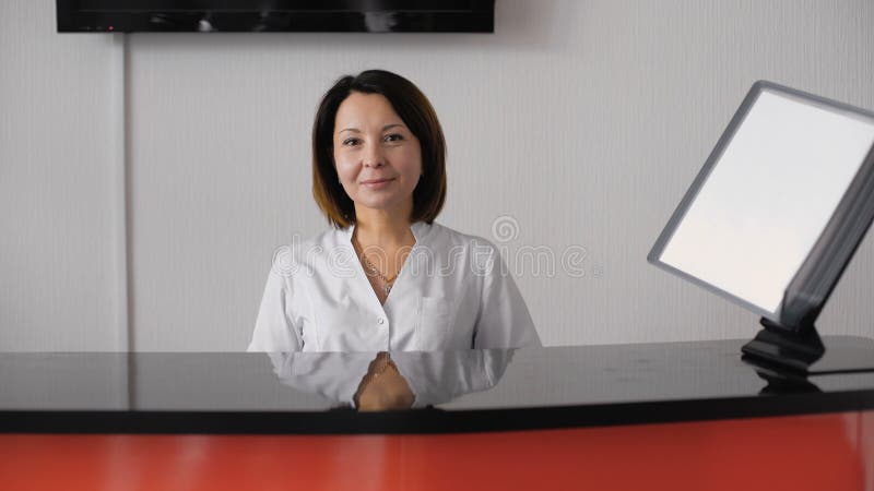 Female Receptionist Working at Hospital Reception Desk Stock Footage ...