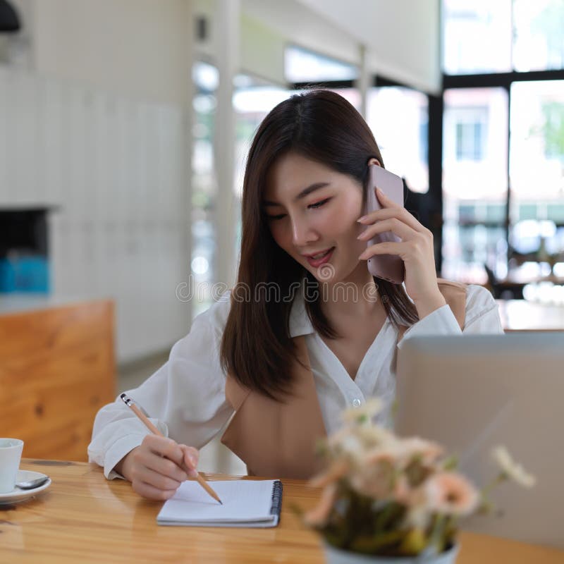 Portrait of Female Talking on the Phone and Taking Note on Blank ...