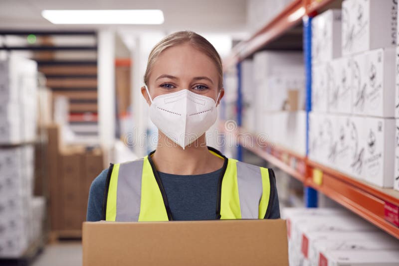 Portrait of Female Worker Wearing PPE Face Mask Holding Box Inside ...