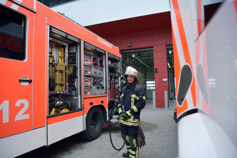 Portrait of a Firefighter at the Emergency Vehicle in the Fire Station ...