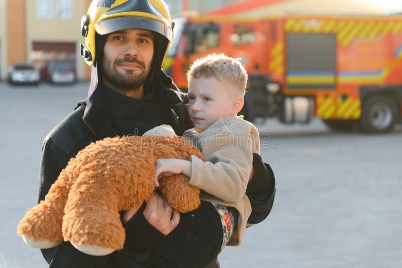 Portrait of a Fireman and a Little Boy with a Teddy Bear. Stock Photo ...