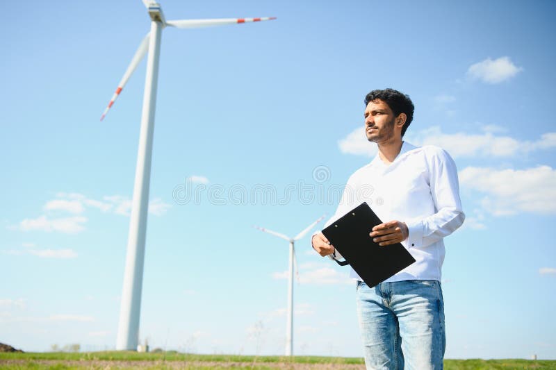 Portrait of Focused Indian Man Standing on Field with Wind Turbines ...