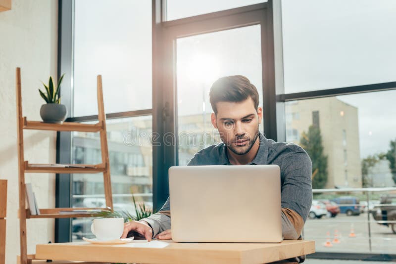 Portrait of Focused Man Using Laptop while Sitting at Table Stock Photo ...