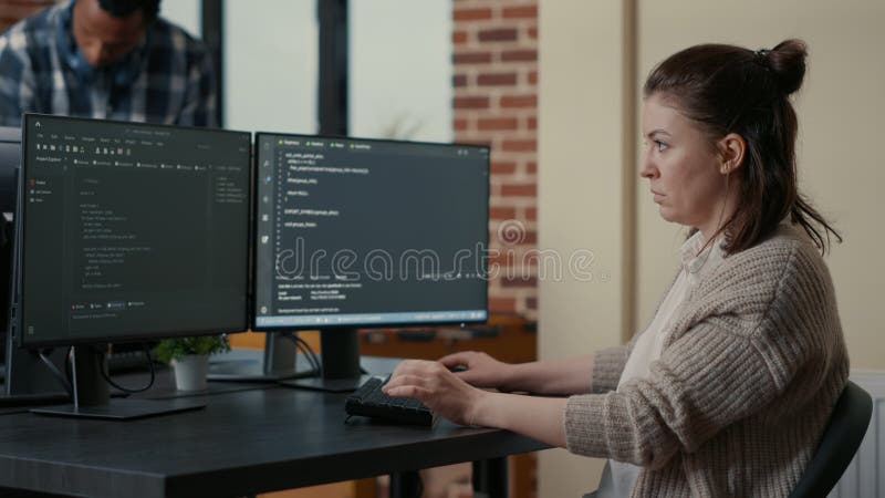 Portrait Of Focused Programer Writing Code Looking At Multiple Computer