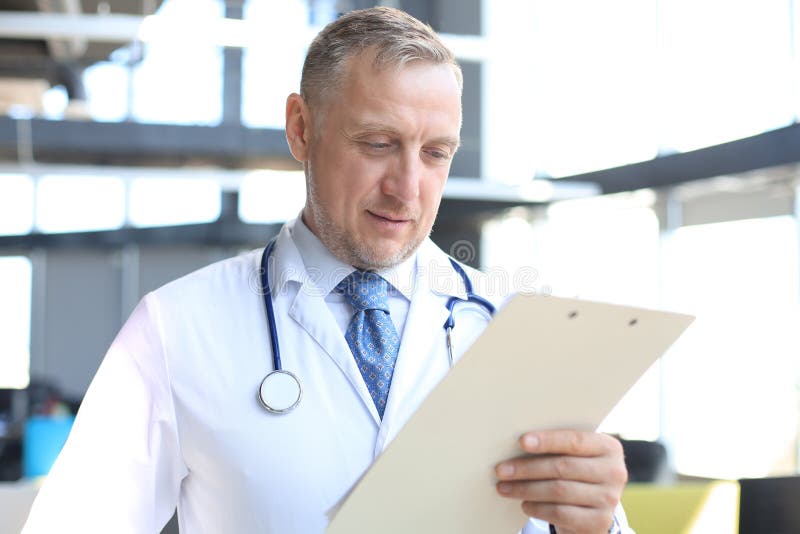 Portrait of Focused Senior Doctor Writing Reports Stock Photo - Image ...
