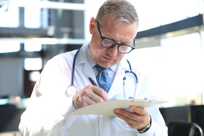 Portrait of Focused Senior Doctor Writing Reports Stock Image - Image ...