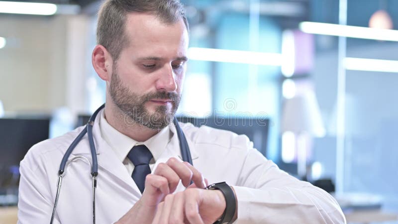 The Portrait of Focused Young Doctor Using Smart Watch Stock Photo ...