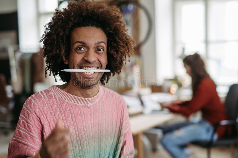 Portrait of Funny Man with Pen in Mouth, Having Fun at Work. Stock ...