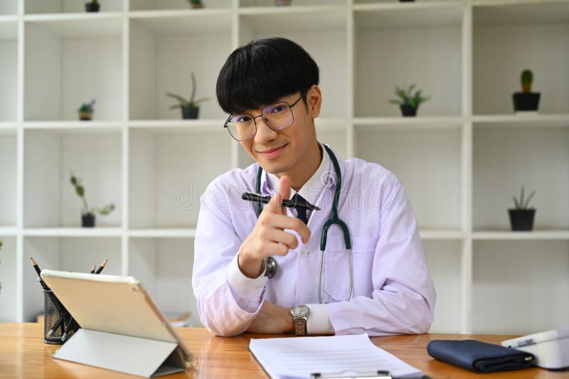 Portrait of General Practitioner Doctor in White Uniform Sitting in ...