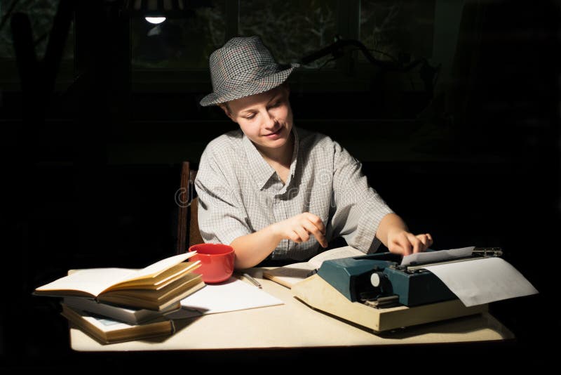 Portrait of a Girl in a Hat Sitting at a Table and Typing on a ...