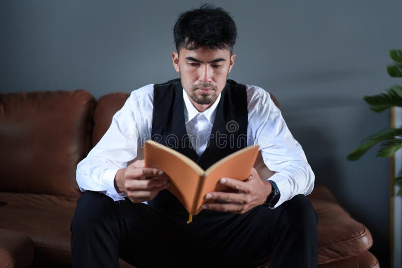 Portrait of a Good Looking Asian Man Sitting on the Sofa Reading a Book ...