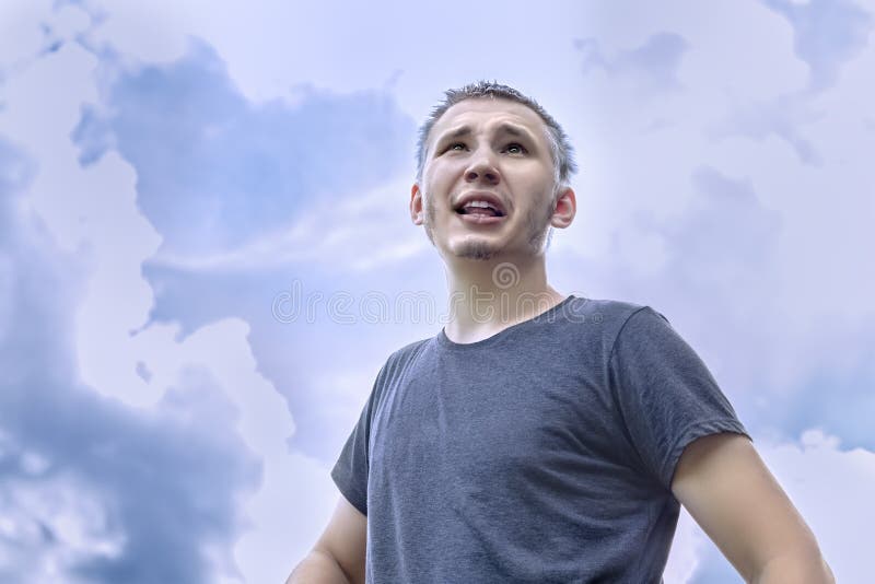 Portrait of a Guy Standing Against a Cloudy Sky with a Desperate ...