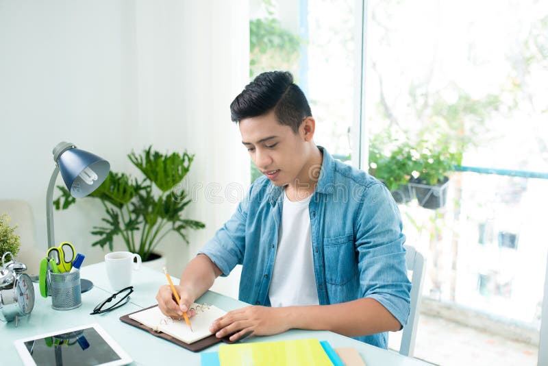 Portrait of Handsome Asian Young Writing Something on Notebook a Stock ...