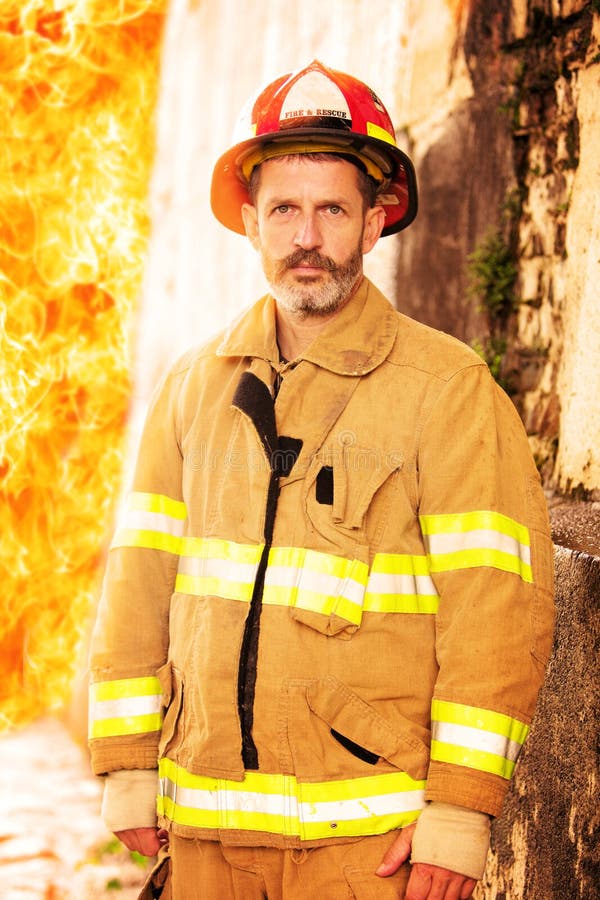 Fireman Standing in Front of Wall of Fire Stock Photo - Image of ...