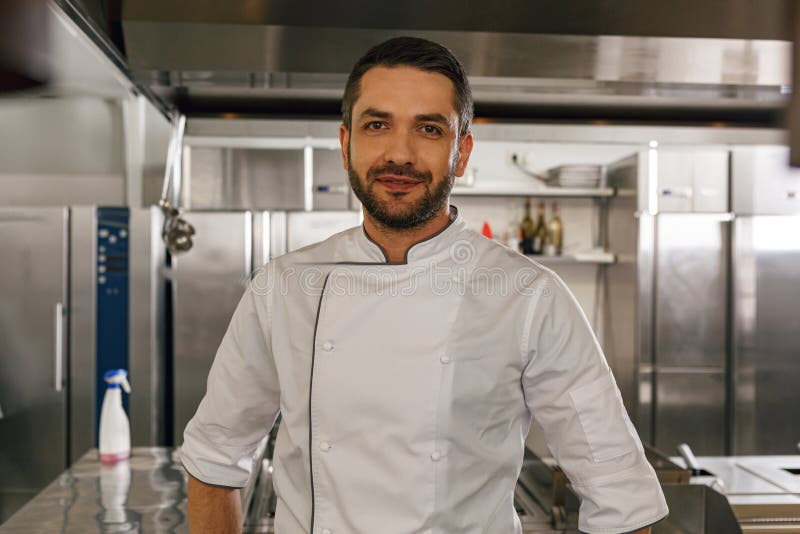 Portrait Of Handsome Male Chef In Uniform Standing On Kitchen Of