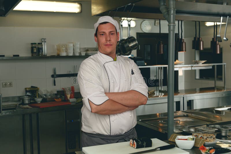 Portrait Of Handsome Male Chef In Uniform Standing On Kitchen Of