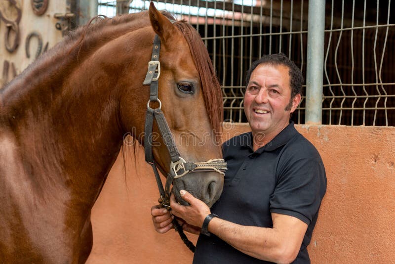 Portrait of a Handsome Man with His Horse Standing at the Stable Stock ...