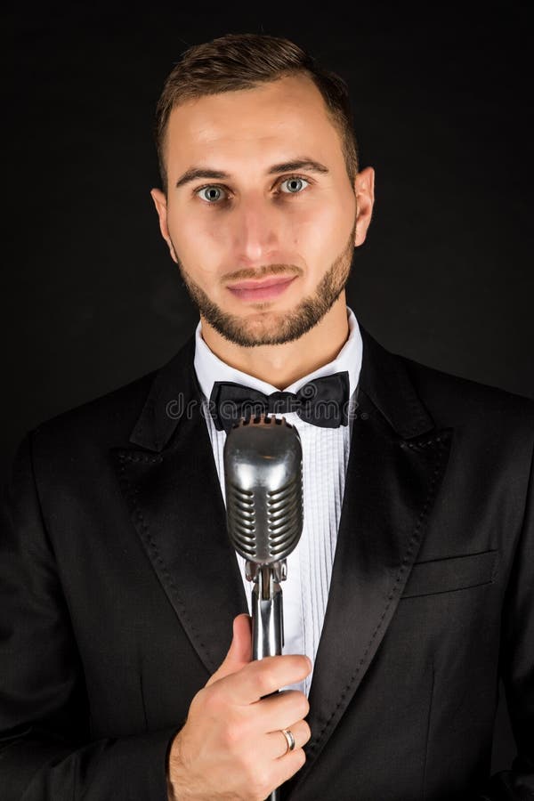 Portrait of Handsome Man Sing on Microphone on Black Background. Stock ...