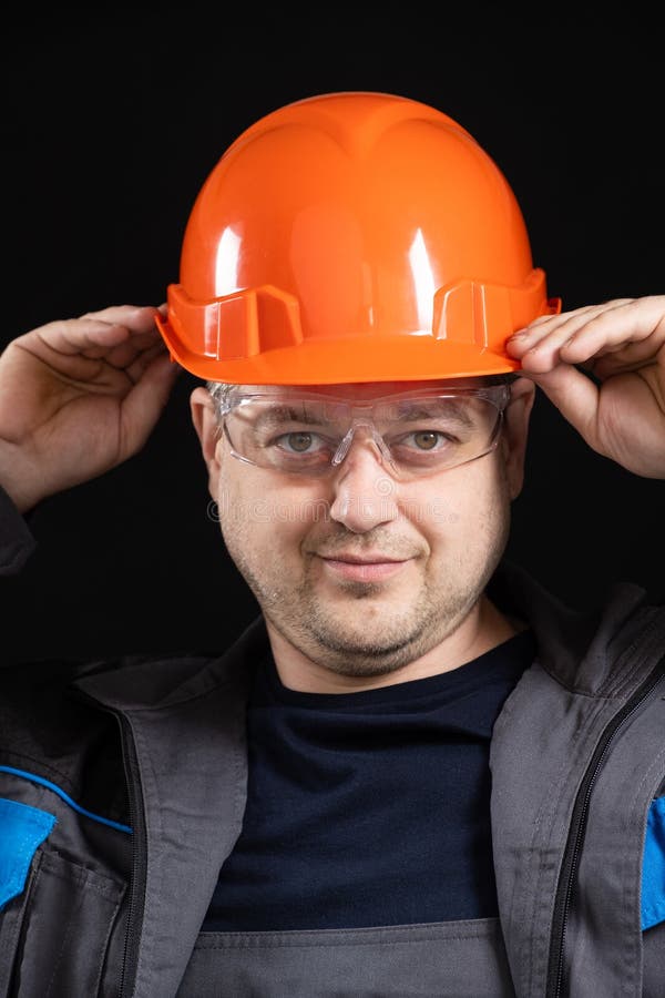 Portrait of a Handsome Worker Builder in Overalls, Helmet and Glasses ...