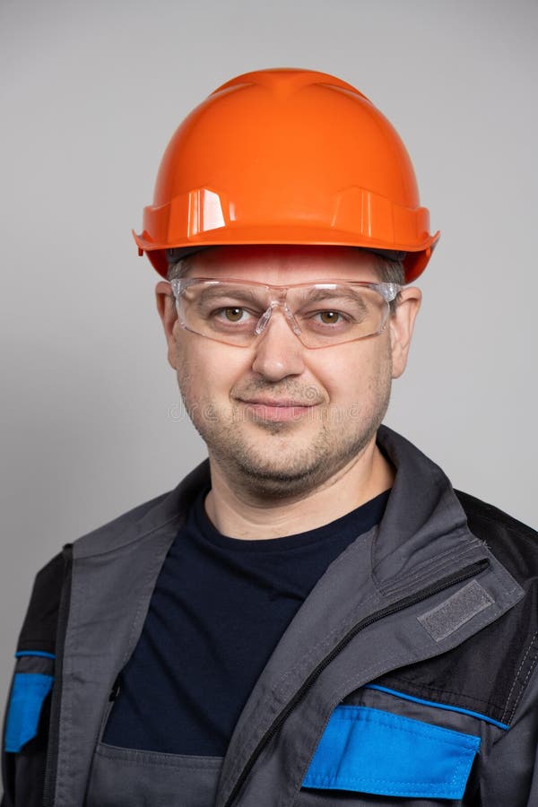 A Young Man Construction Worker in a Safety Helmet and Work Uniform on ...