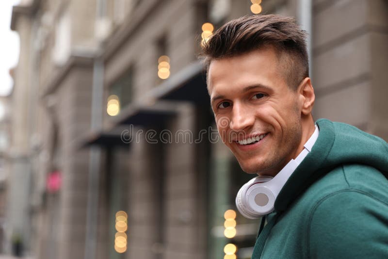 Portrait of Handsome Young Man with Headphones Outdoors. Space for Text ...