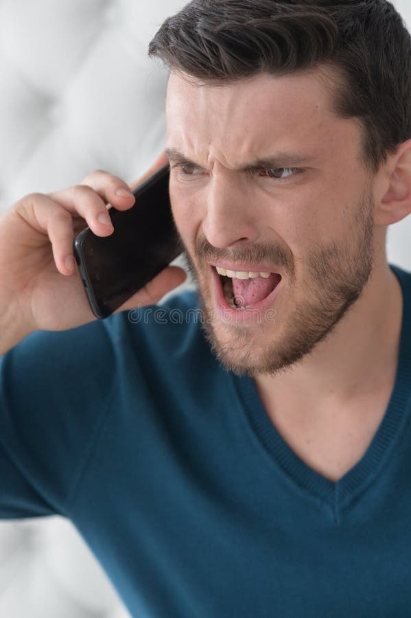 Portrait of Handsome Young Man Shouting on Smartphone Stock Photo ...