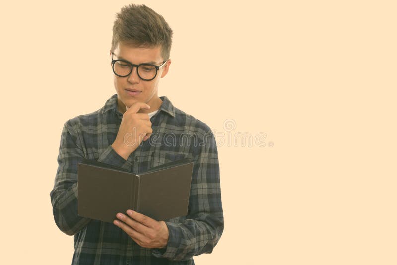 Studio Shot of Young Handsome Man Reading Book while Thinking Stock ...