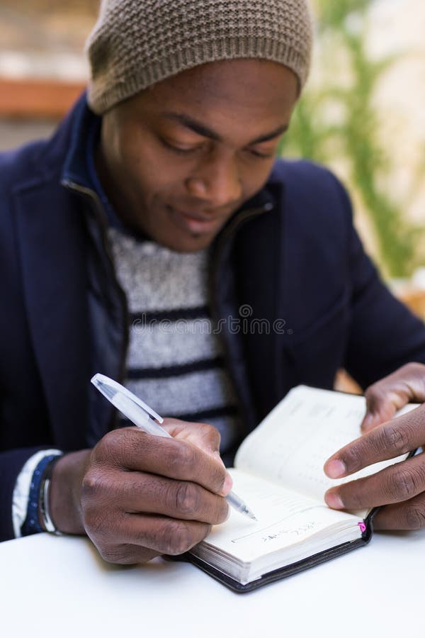 Handsome Young Man Writing in a Notebook. Stock Photo - Image of ...