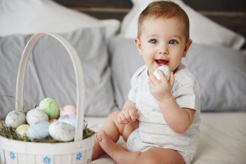 Portrait of Baby Eating Easter Egg in Bed Stock Photo - Image of ...