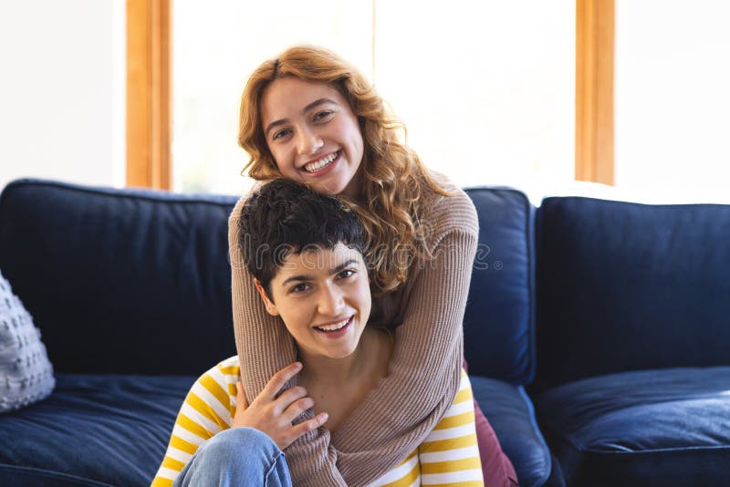 Portrait Of Happy Biracial Lesbian Couple Embracing And Smiling On