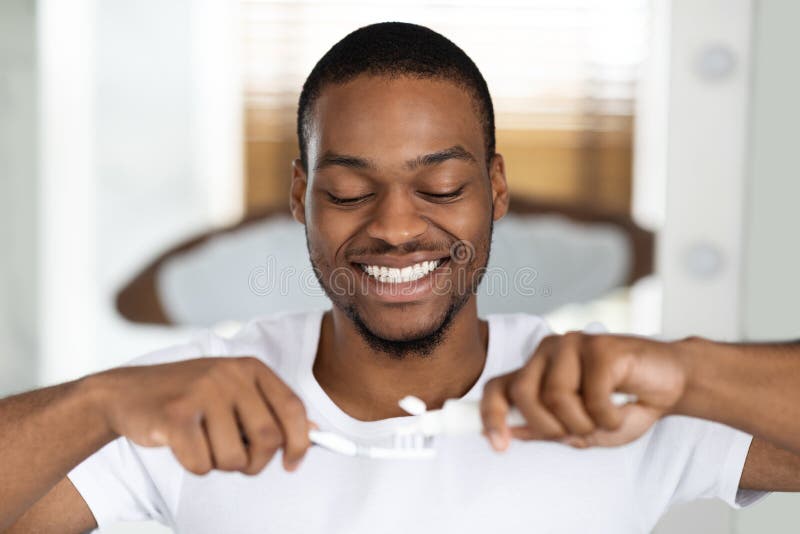 Portrait of Happy Black Guy Squeezing Toothpaste on Toothbrush in ...