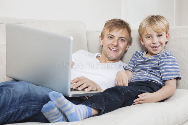 Portrait of Happy Boy with Father Using Laptop on Sofa Stock Photo ...
