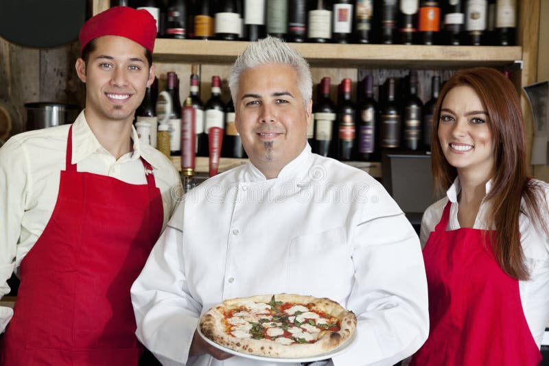 Portrait of a Happy Chef Holding Pizza with Wait Staff Stock Image ...